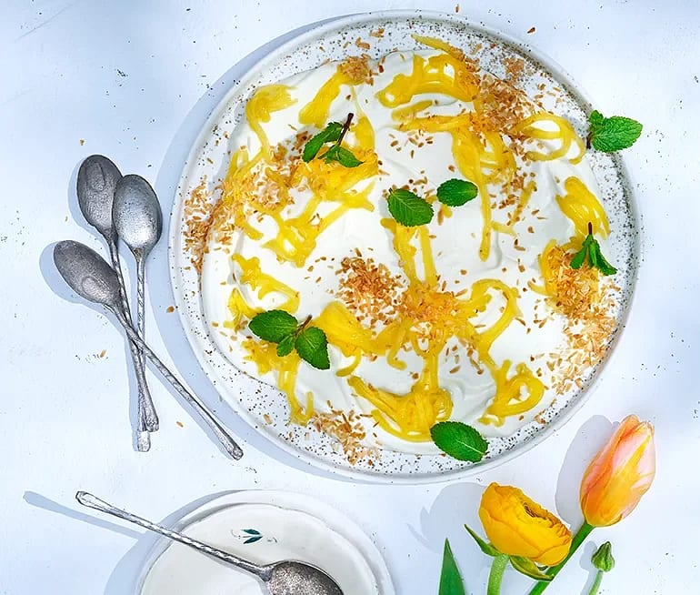 Vit chokladkvarg med kokos, frusen riven mango och mynta | Recept ICA.se
