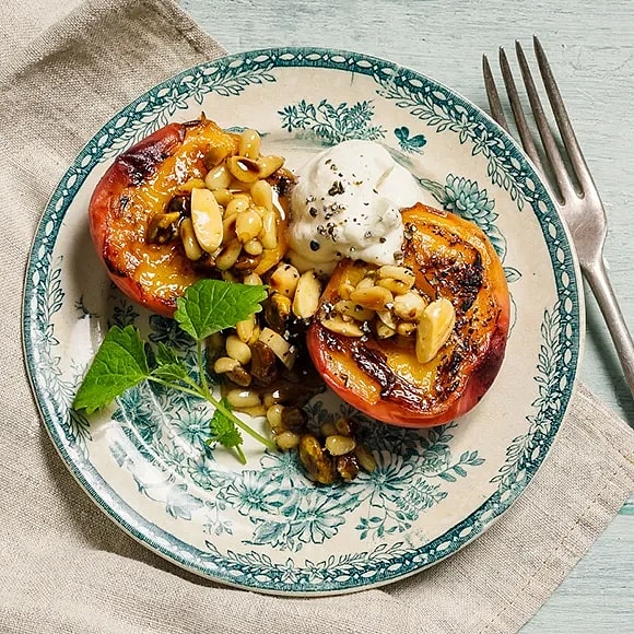 Grillade persikor med kardemummagrädde och nötter | Recept ICA.se